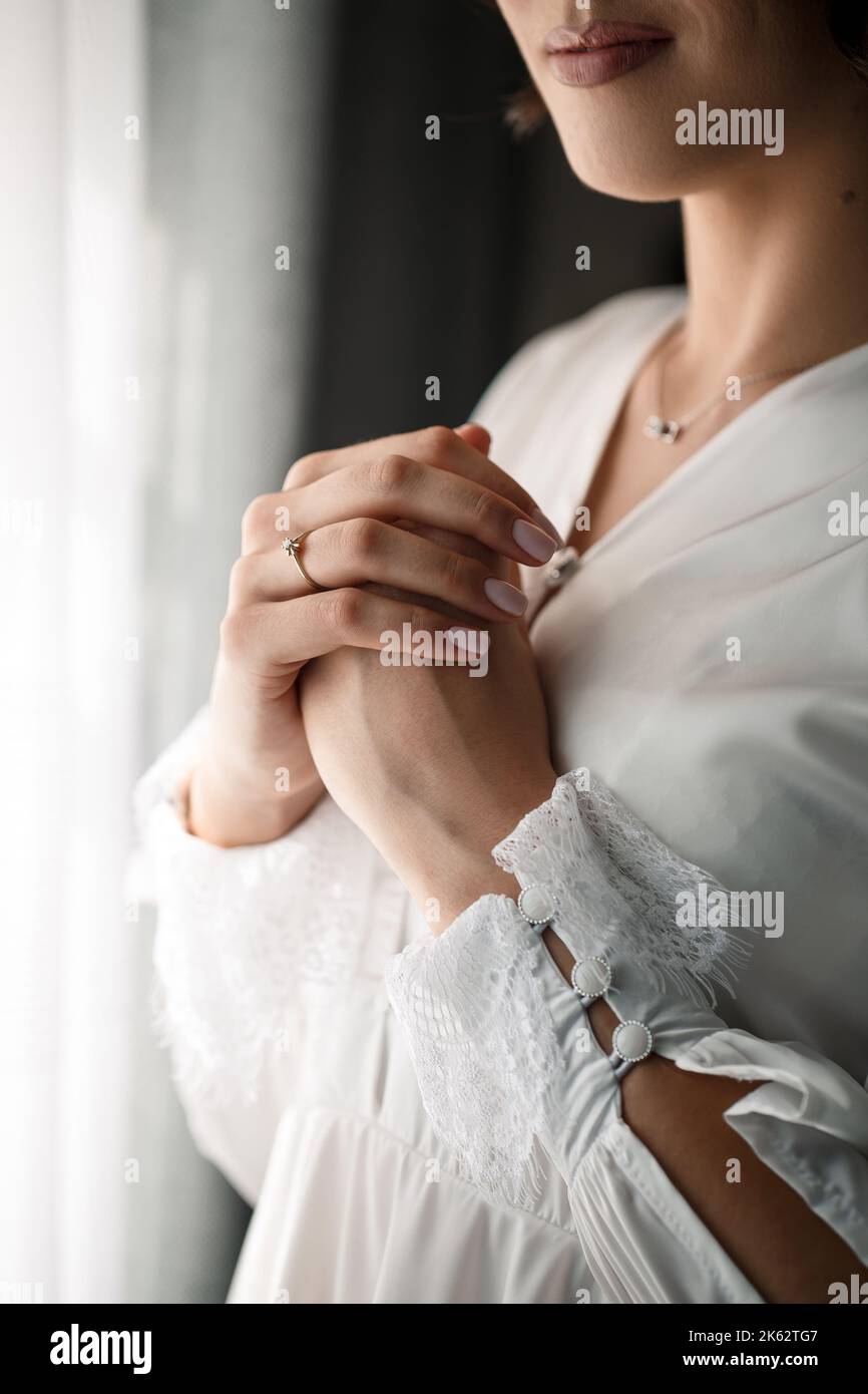 Gentle female hands of the bride with a gold wedding ring on the ring ...