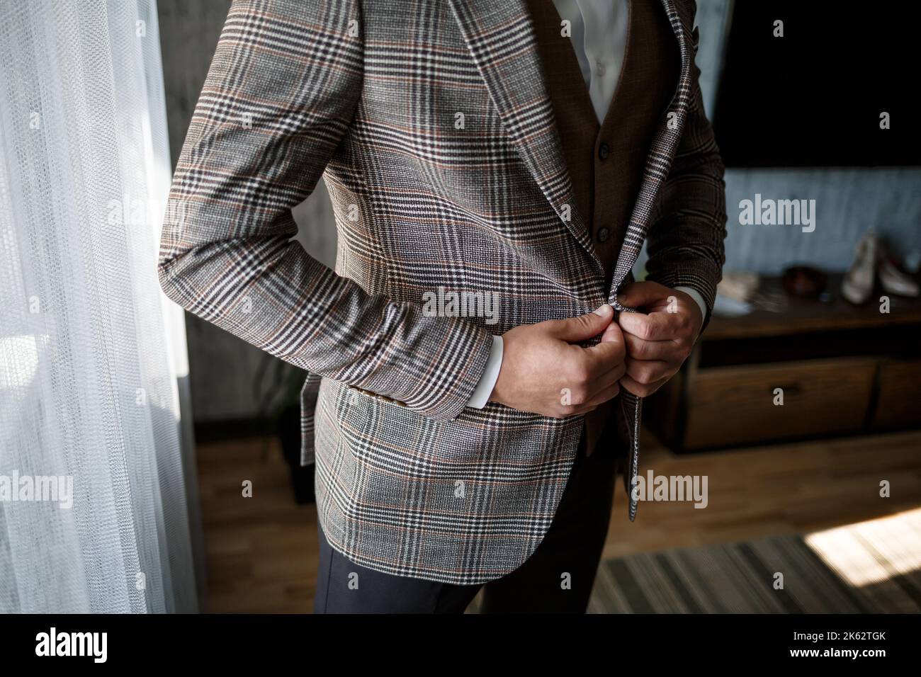 Stylish man groom buttoning a button on his jacket Stock Photo - Alamy