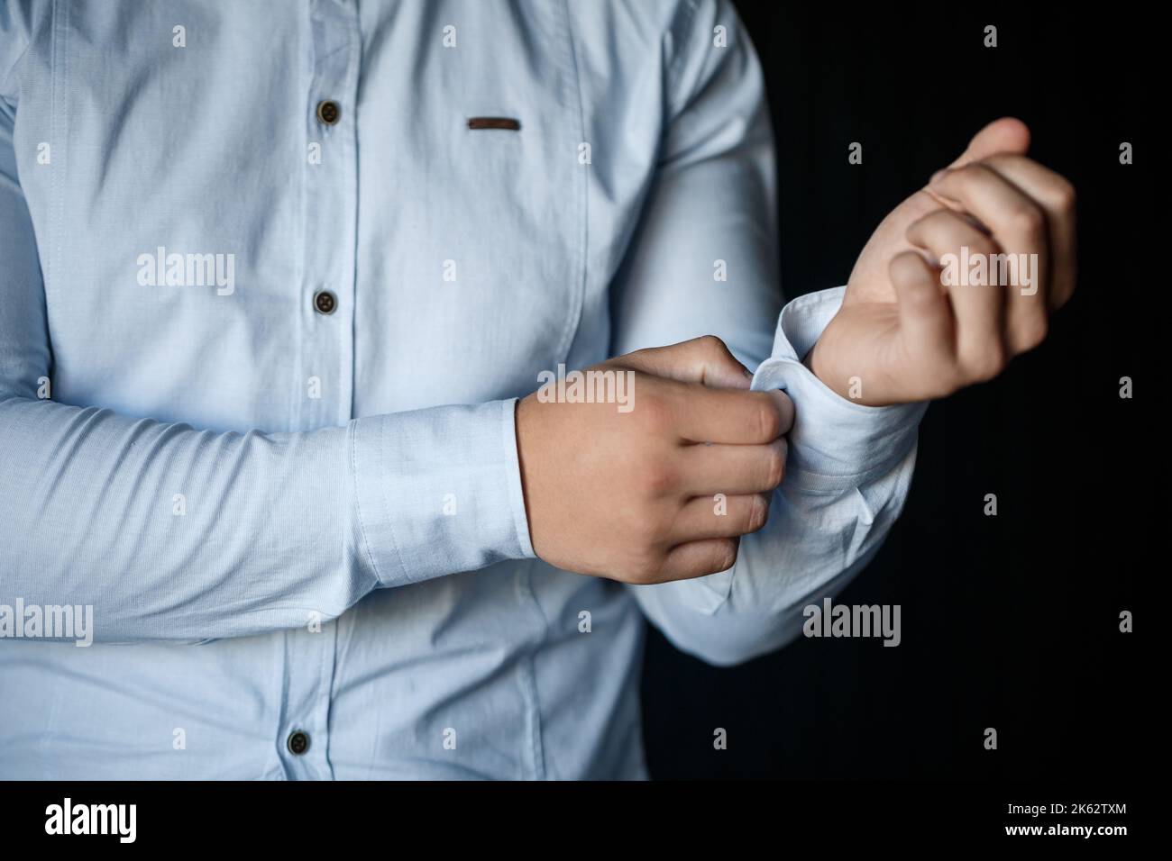 Man businessman buttoning a button on the sleeve of a white dress shirt ...