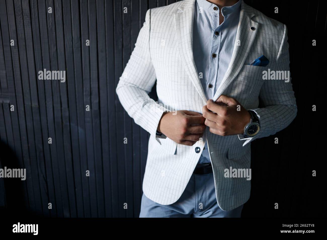 Stylish man groom buttoning a button on his jacket Stock Photo - Alamy