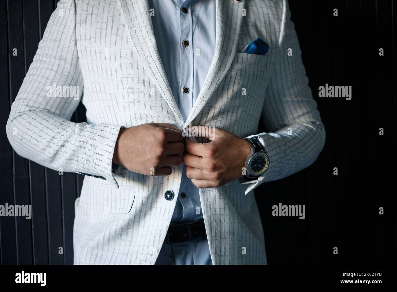 Stylish man groom buttoning a button on his jacket Stock Photo - Alamy