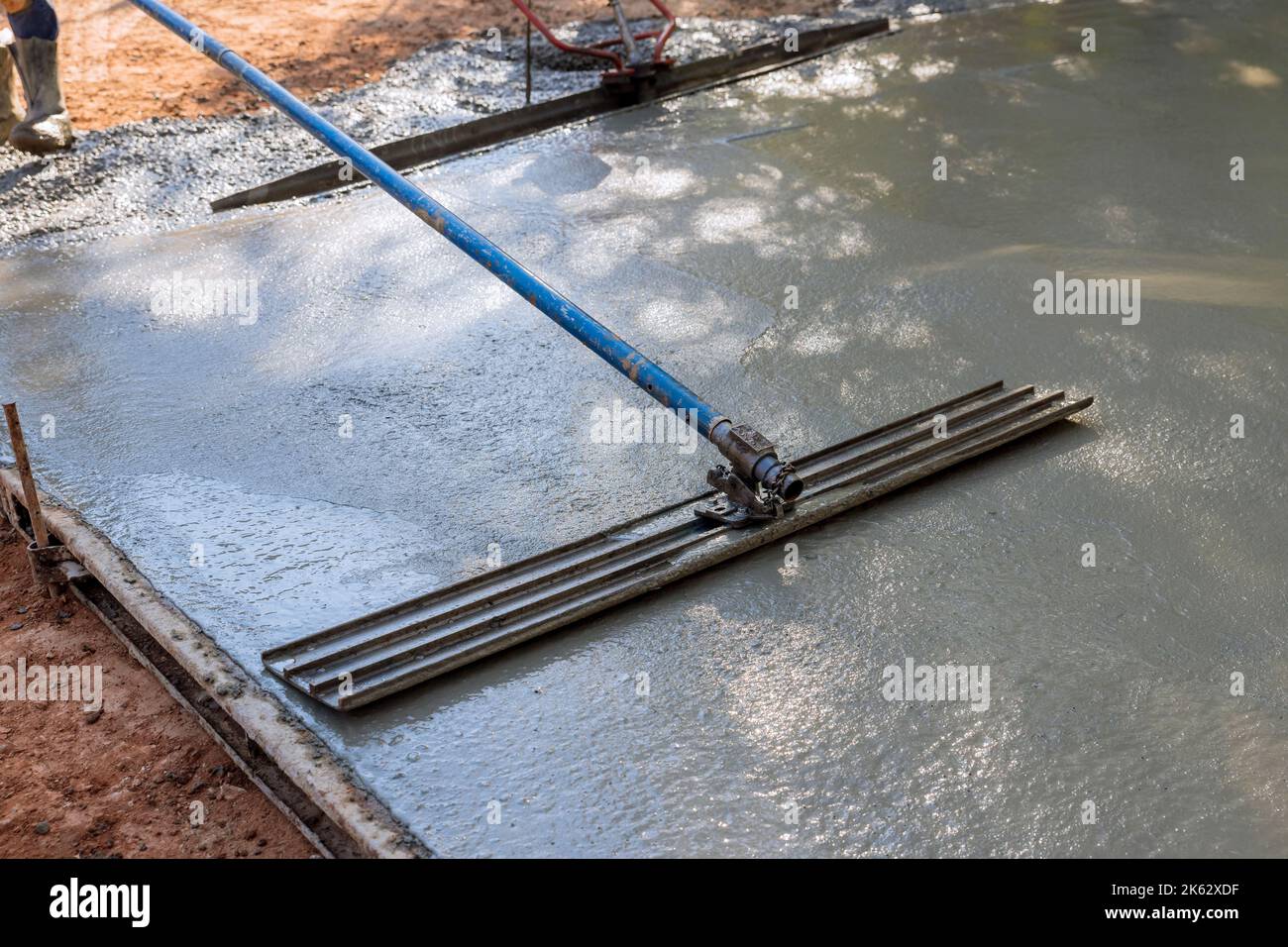 Plastering cement concrete patio floor with by using long trowel was ...