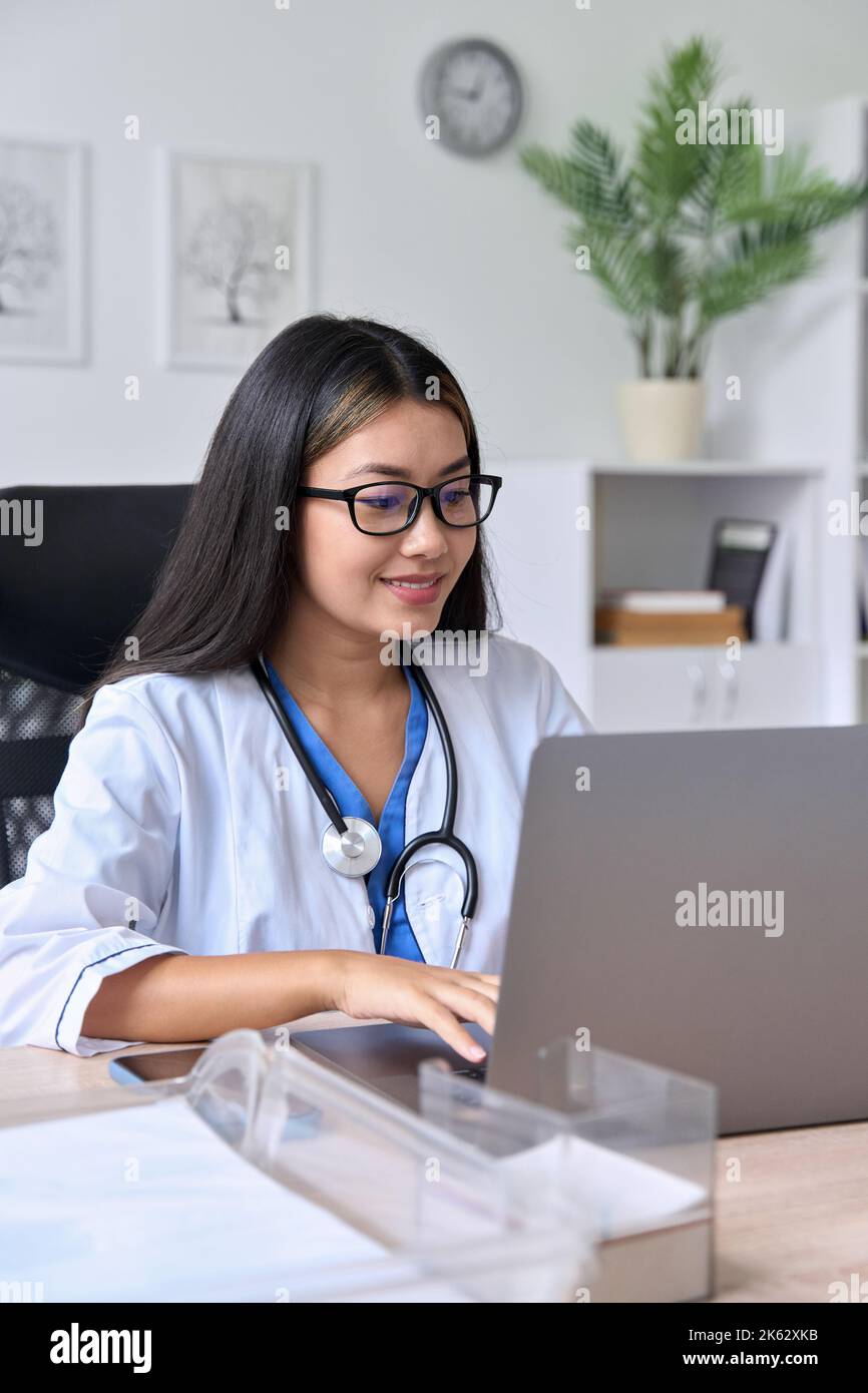 Young Asian female doctor using computer laptop talking video ...