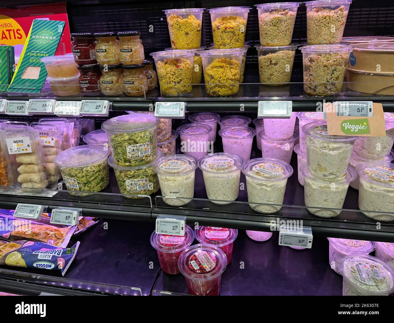 The Veggie food in containers on the shelves of a fridge in the ...