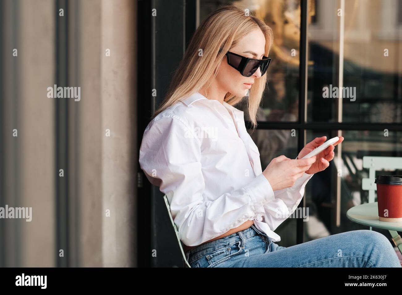 Side View of Elegant Caucasian Woman Sitting at a Cafe Table and ...