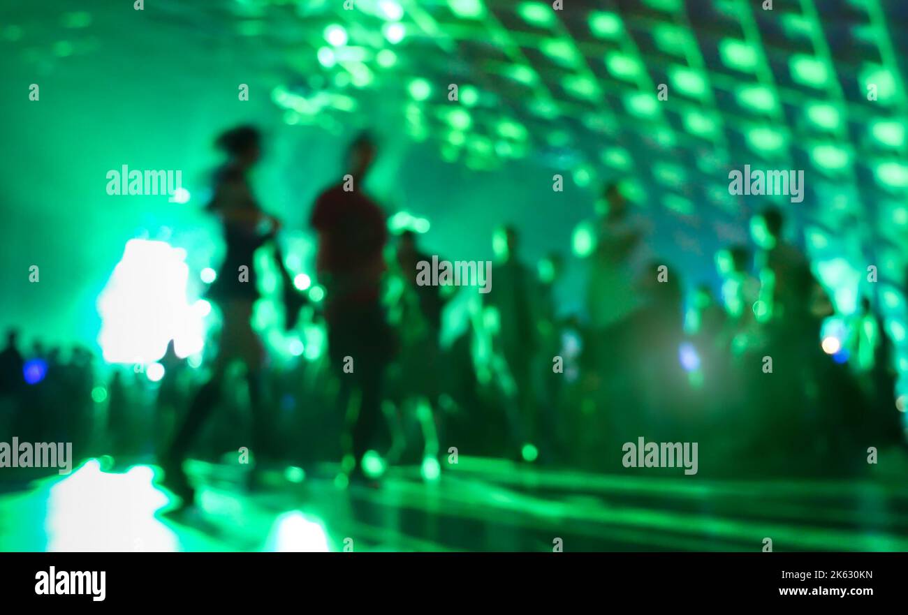 Abstract blurred people moving on and dancing at music night festival ...