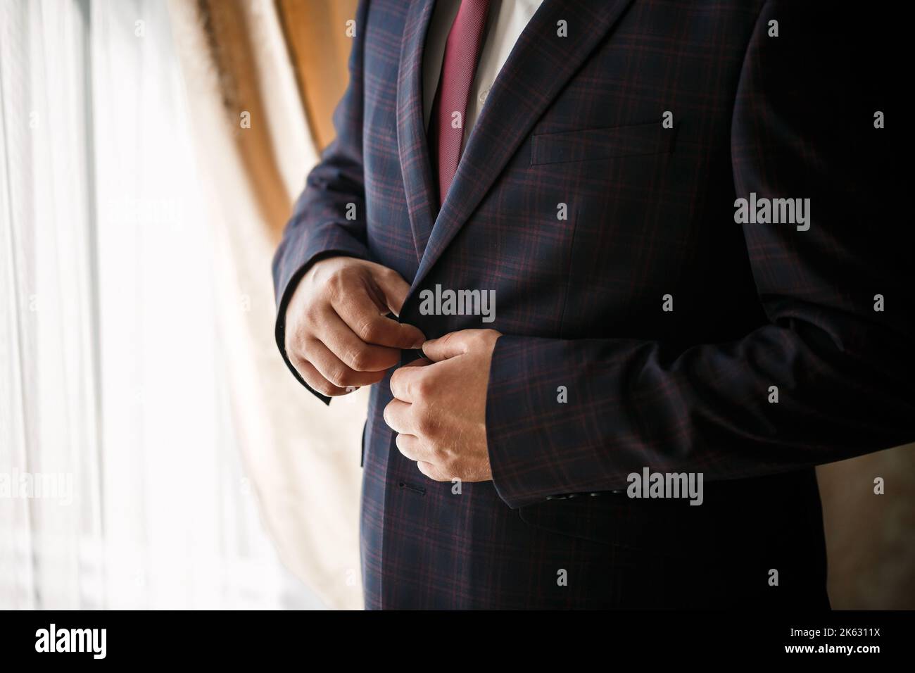 Stylish man groom buttoning a button on his jacket Stock Photo - Alamy
