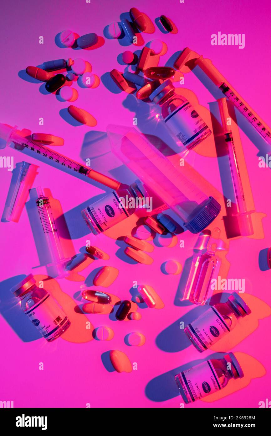 covid-19 medication neon vaccine syringe pills Stock Photo - Alamy
