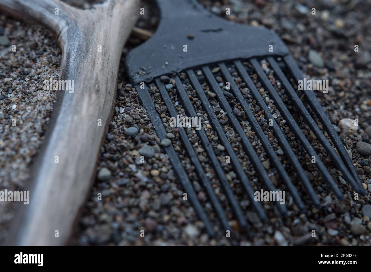 Black hair comb on a beach sifting through tiny pebbles Stock Photo - Alamy