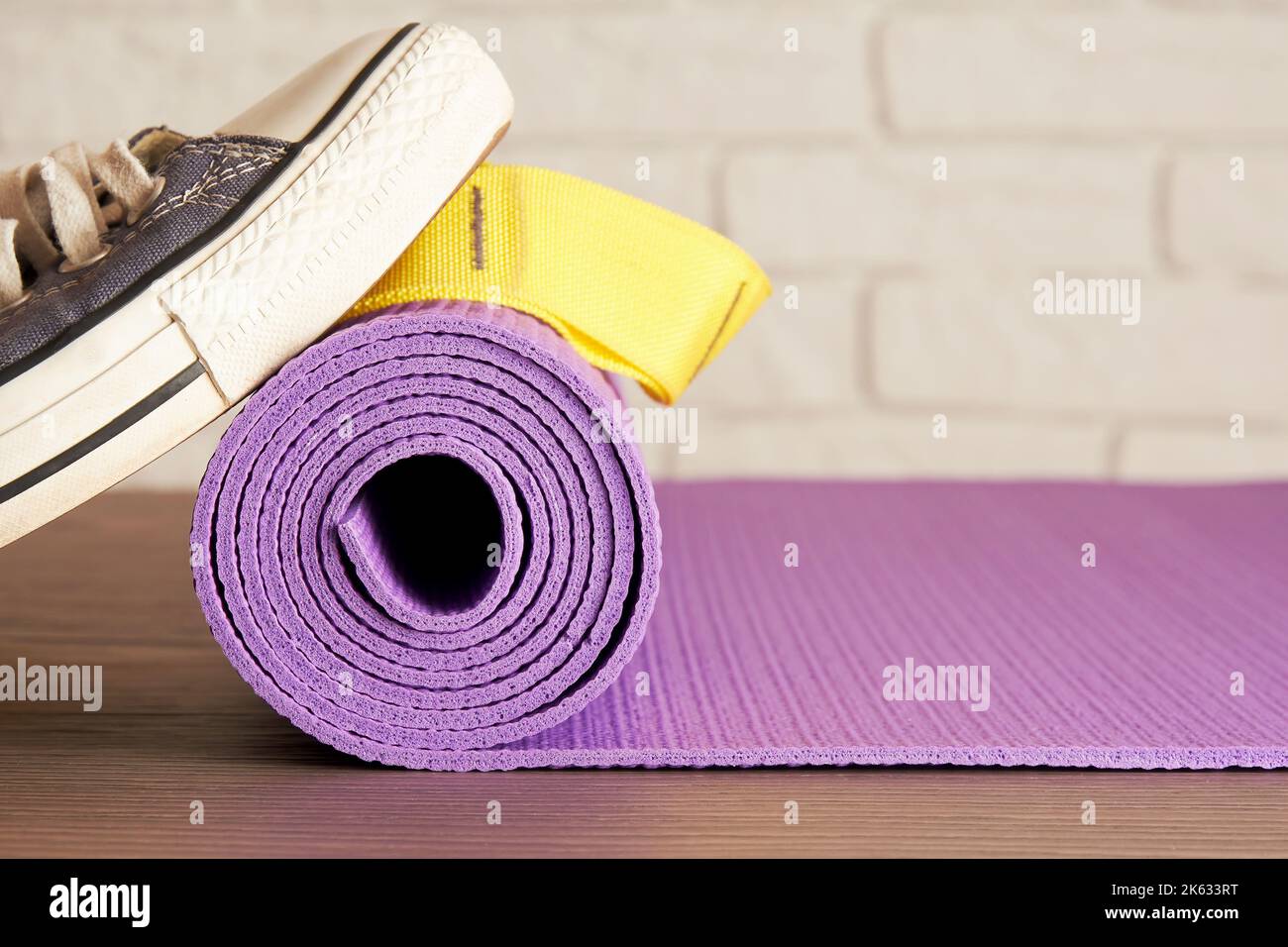 Yoga mat, belts and sneakers on the floor in the modern gym. Sports and ...