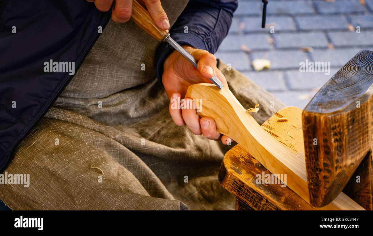 Hands carving spoon from wood, working with chisel close up. Process of ...