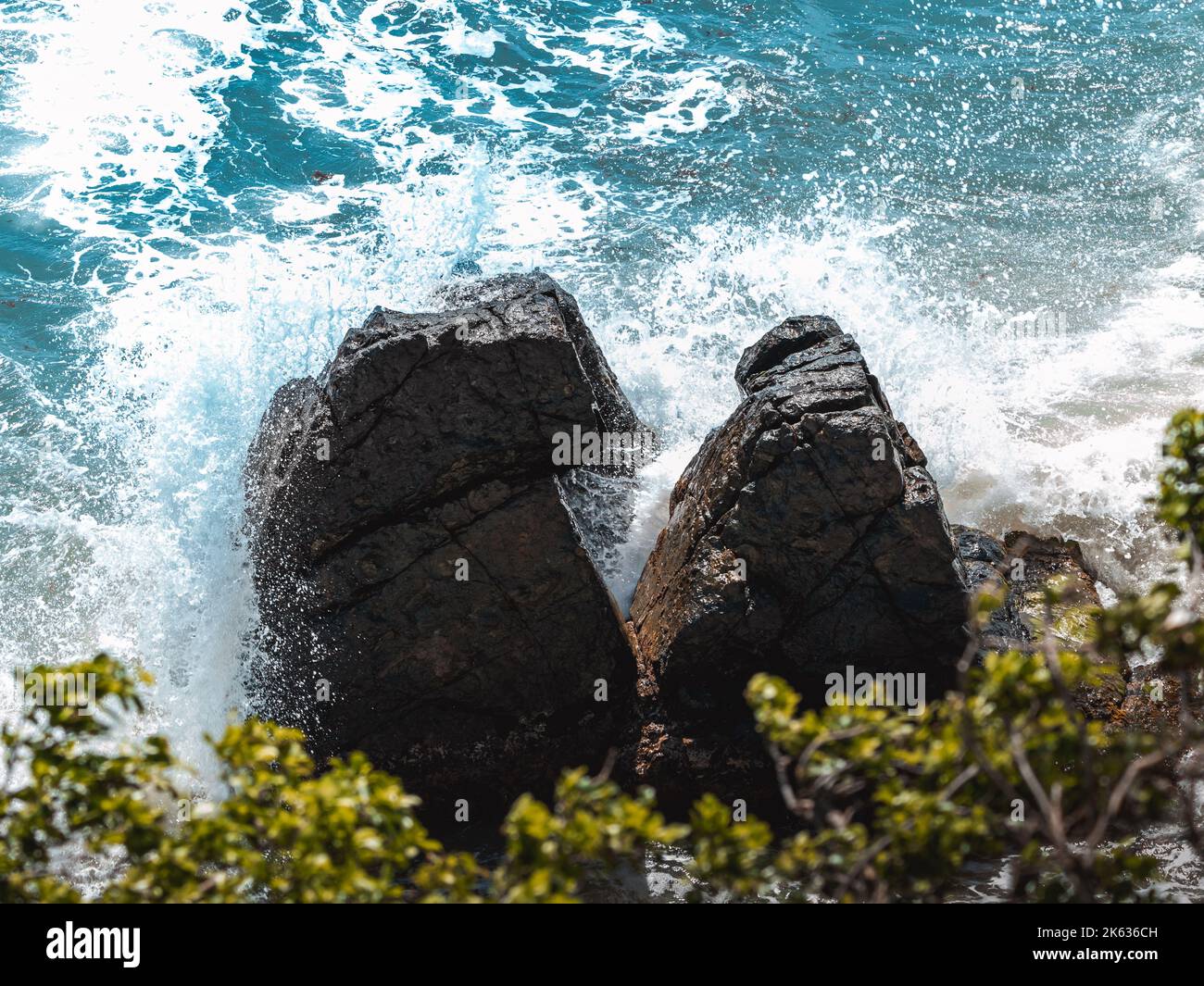 Tropical island beach with huge rock and water splashing from puerto ...