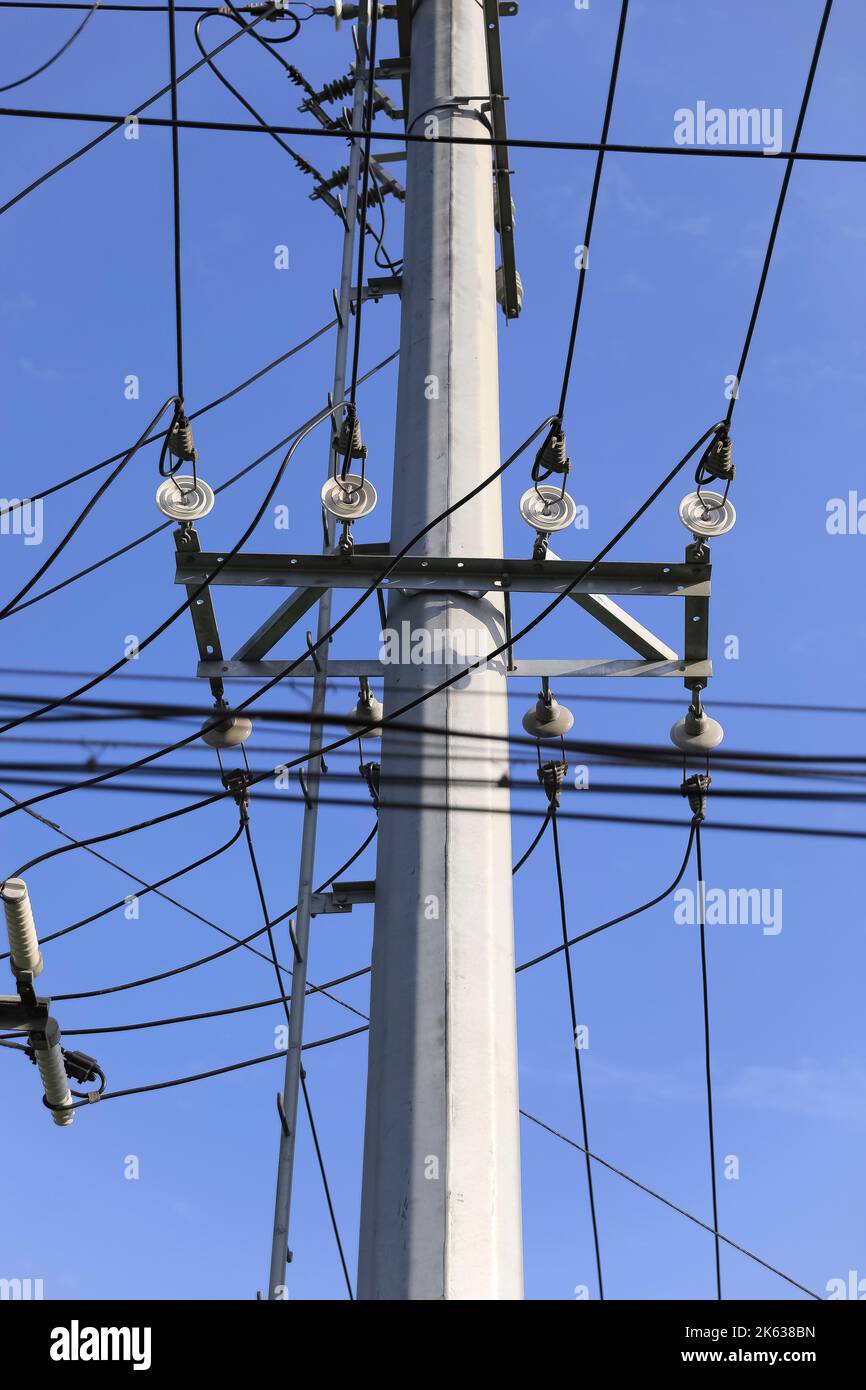 A vertical shot of an electrical post with steel cables connected to it ...