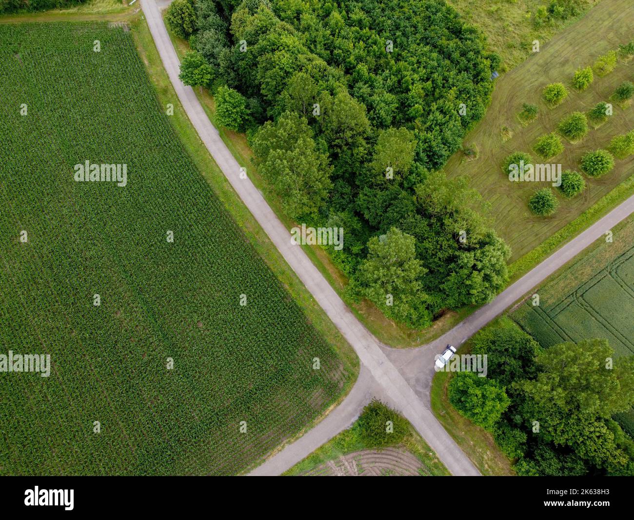 An aerial view of a crossroad passing through green field Stock Photo ...