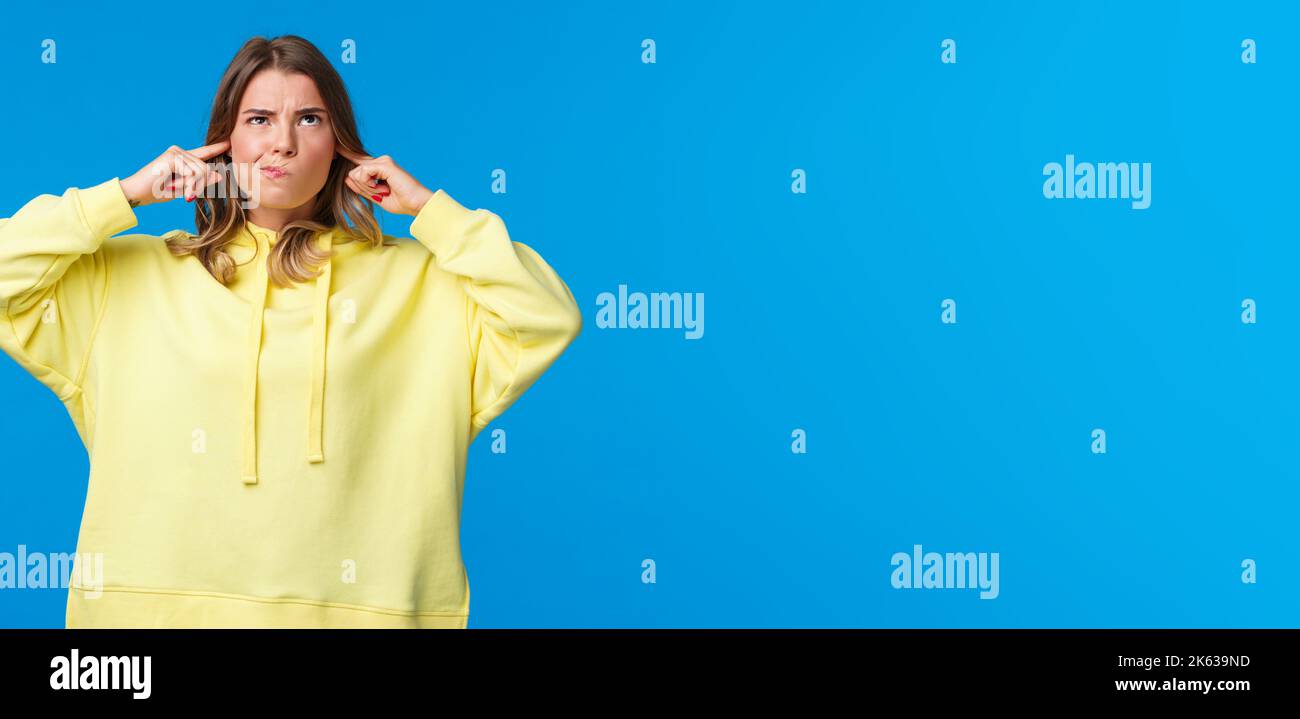 Disturbed and bothered young blong woman with pissed-off expression ...