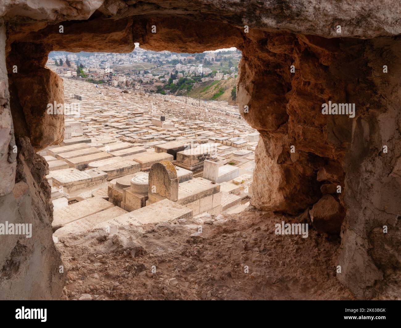 Looking at the ancient cemetery in Jerusalem through a window in a wall ...