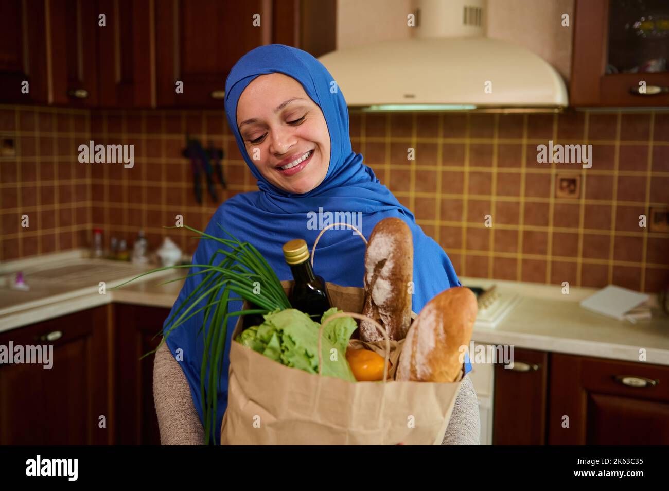 Food delivery. Beautiful Middle-Eastern Muslim woman wearing a blue ...