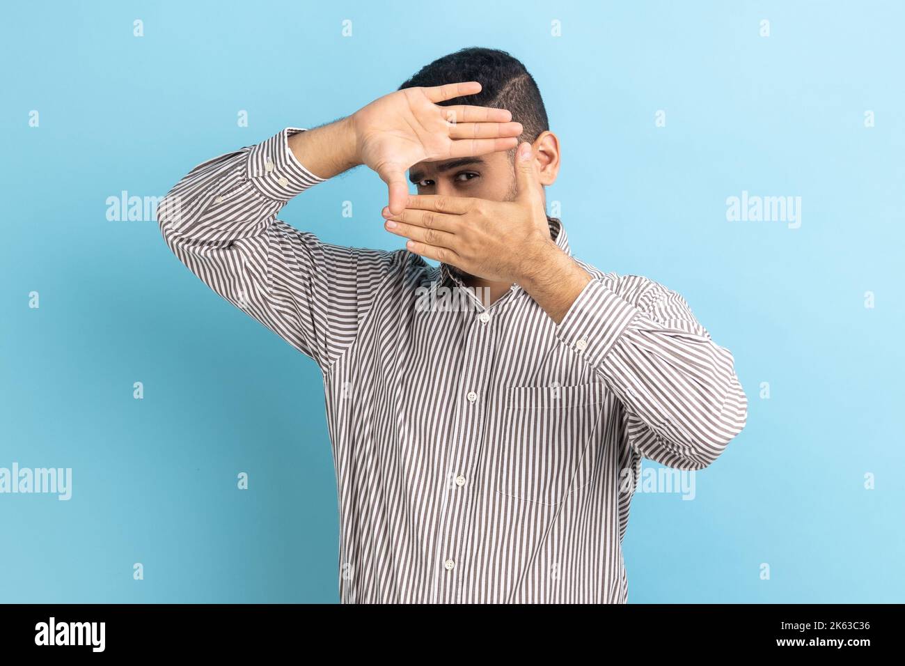 Creative businessman looking through hand frame gesture, cropping image ...