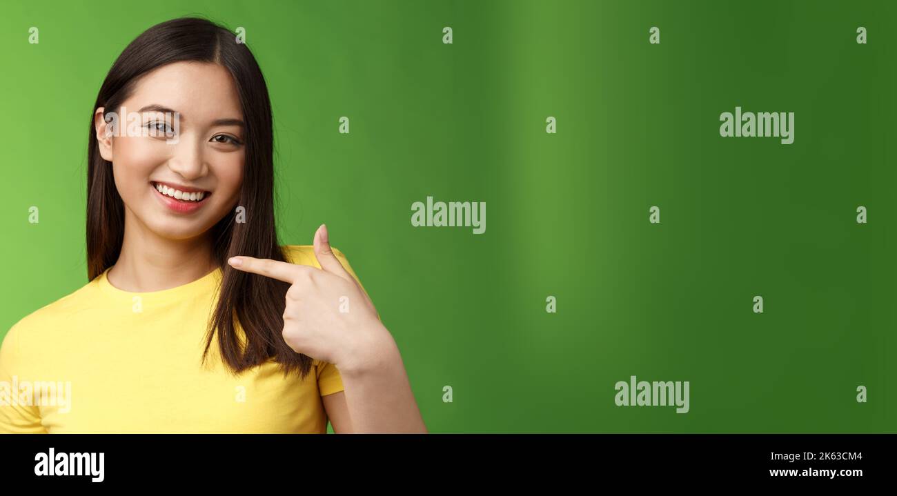 Close-up joyful proud asian assertive girl introduce herself, pointing ...