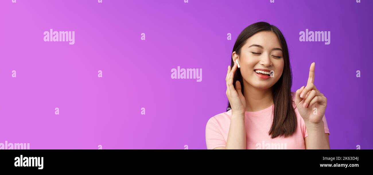 Close-up cheerful glad attractive asian woman close eyes raising one ...