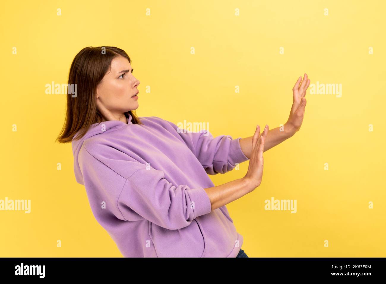 No, it's scary. Side view of frightened shocked woman raising hands in ...