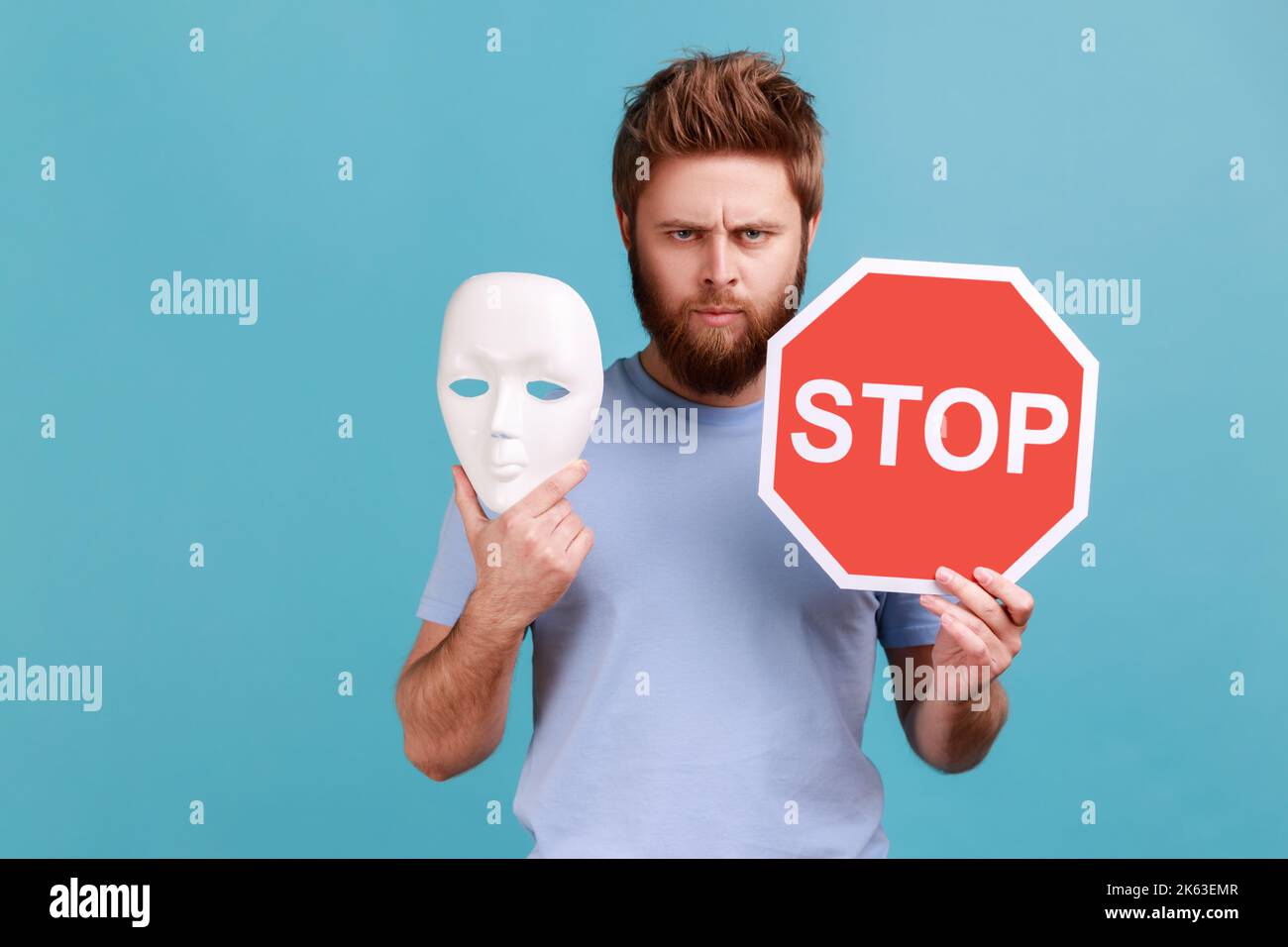 Portrait of bossy serious handsome bearded man holding red stop sign ...