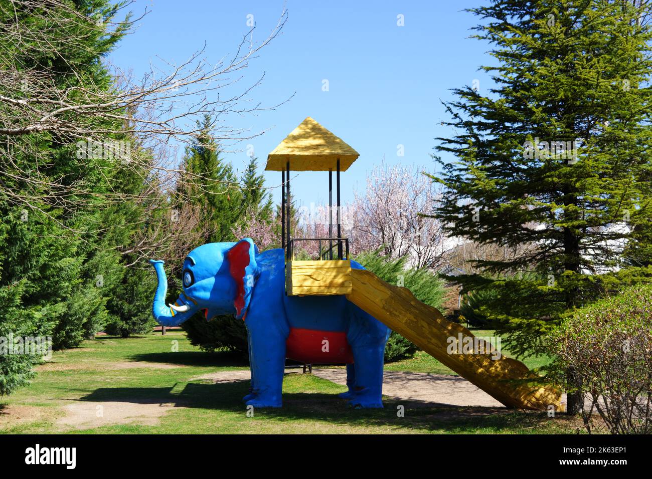 Blue elephant shaped slide within trees on grass in summer Stock Photo ...
