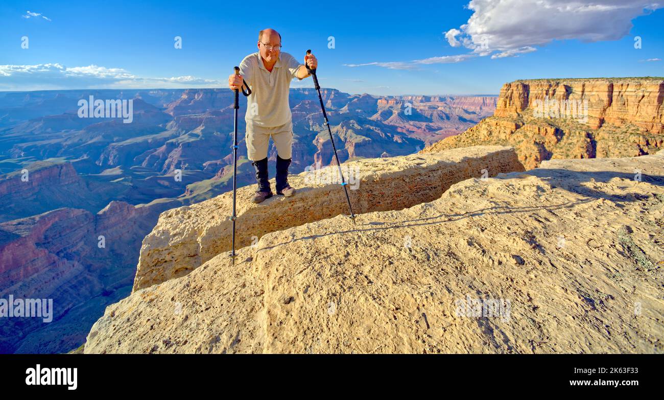 A hiker on the edge of a cliff between Moran Point and Zuni Point at ...