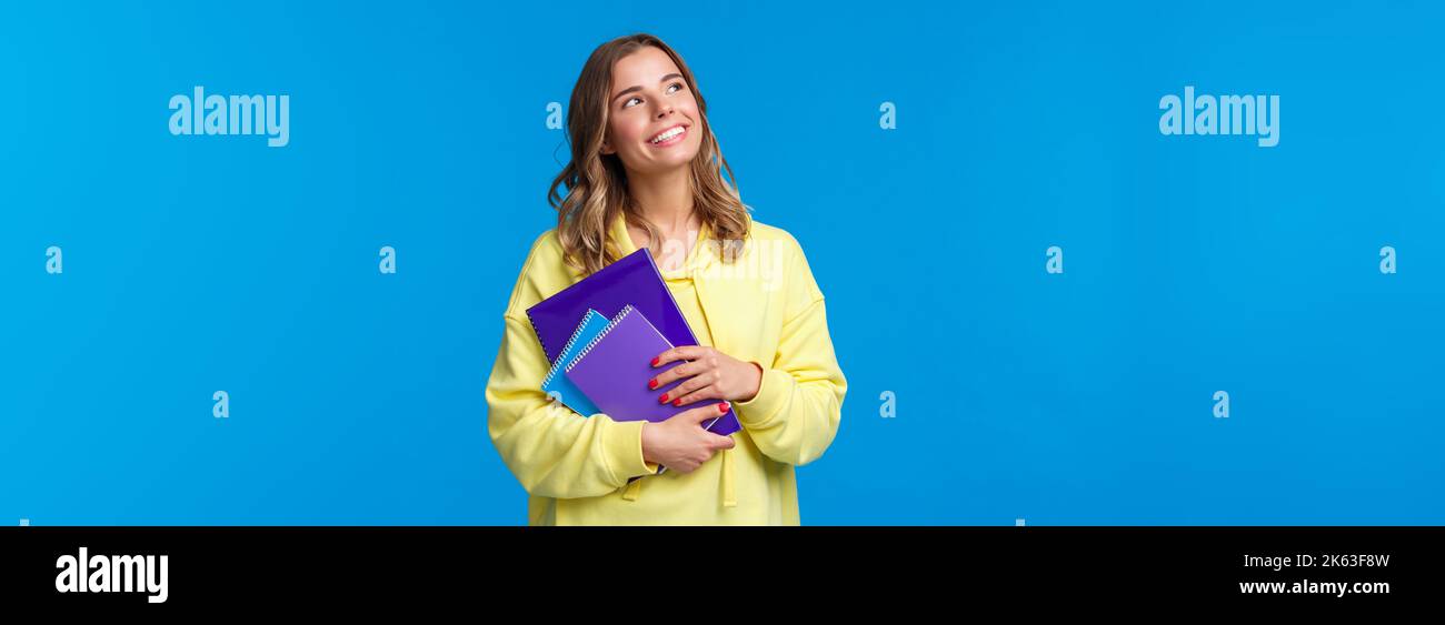Back to school. Cute blond smiling european female student carry ...