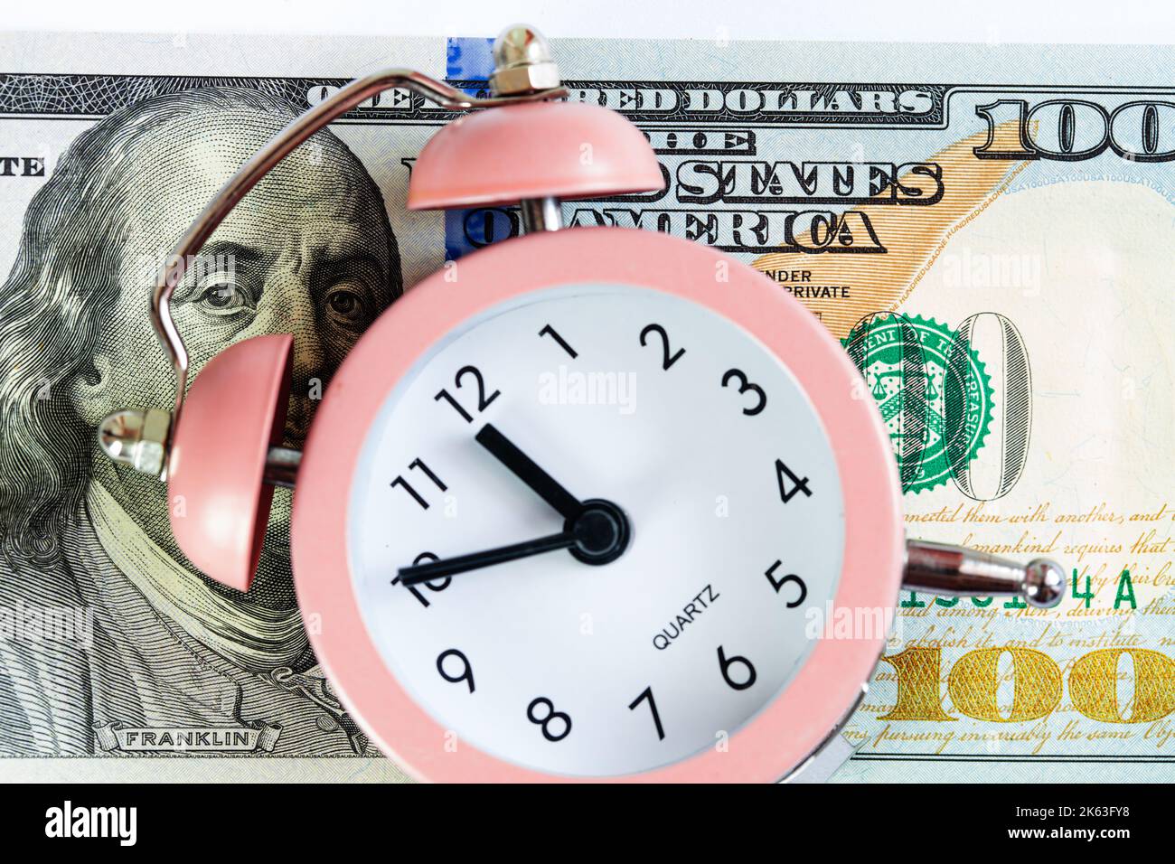 pink quartz alarm clock isolated on 100 dollar background for design ...