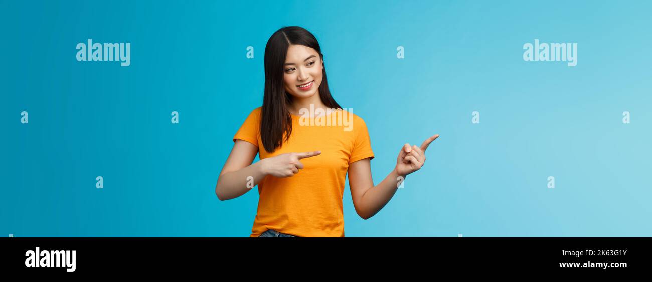 Tender lovely asian girl with dark haircut look curiously pointing left ...