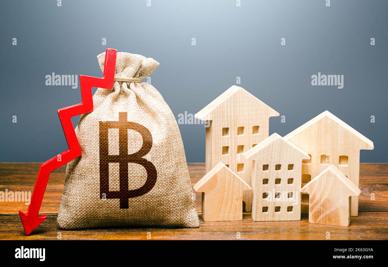 Houses and thai baht money bag with down arrow. Reducing maintaining ...