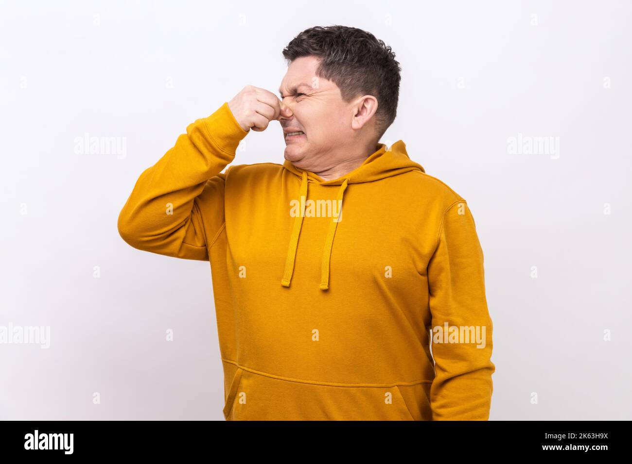 Middle aged man holding breath and grimacing in disgust, expressing ...