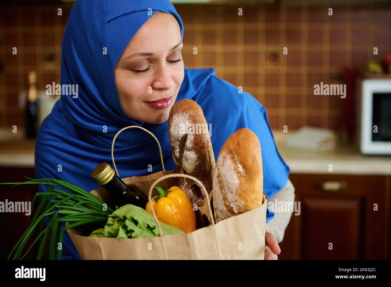 Muslim woman of Middle Eastern ethnicity, in a blue hijab, posing with ...