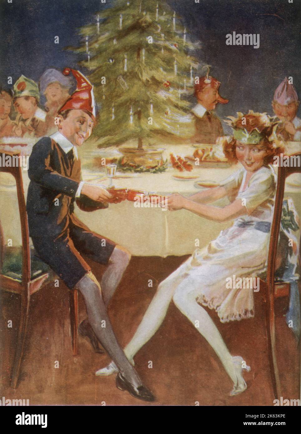 Boy and girl in paper hats pull a cracker at the party table Stock ...
