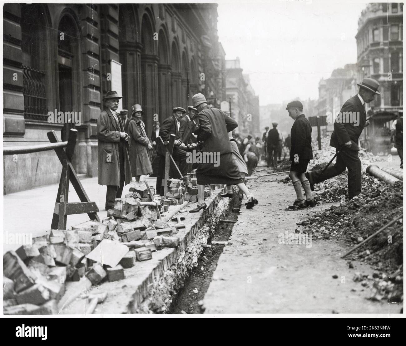 Pedestrians clamber over street roadworks in Piccadilly in a rather ...