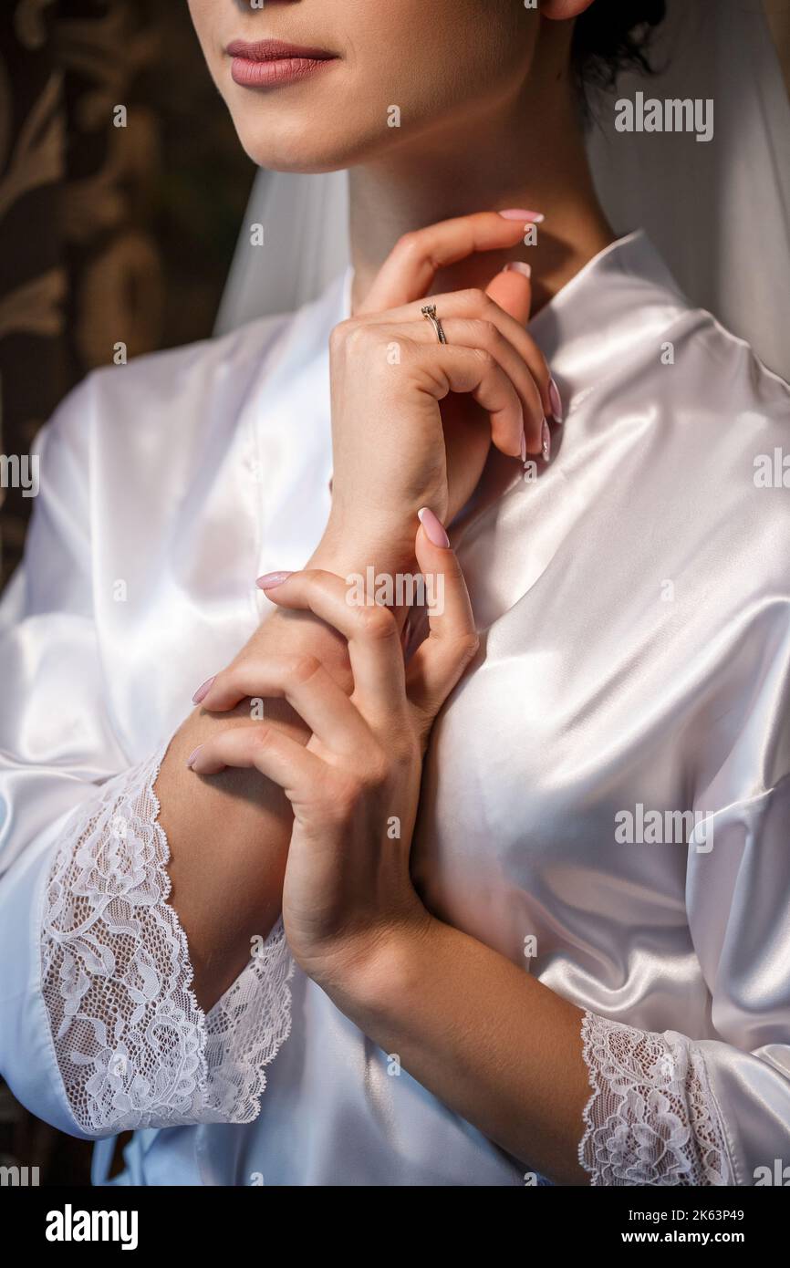 Gentle female hands of the bride with a gold wedding ring on the ring ...