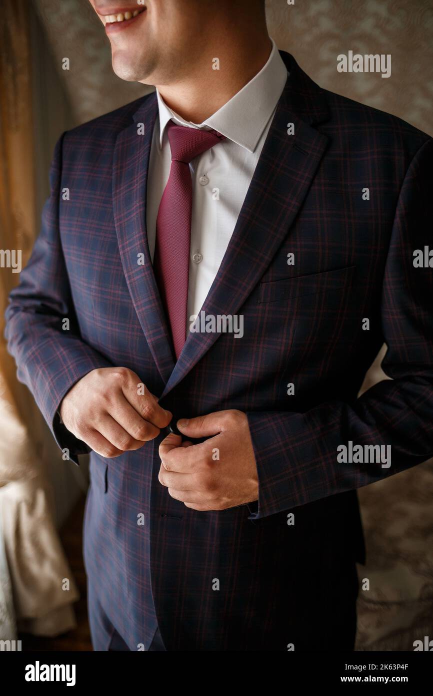 Stylish man groom buttoning a button on his jacket Stock Photo - Alamy