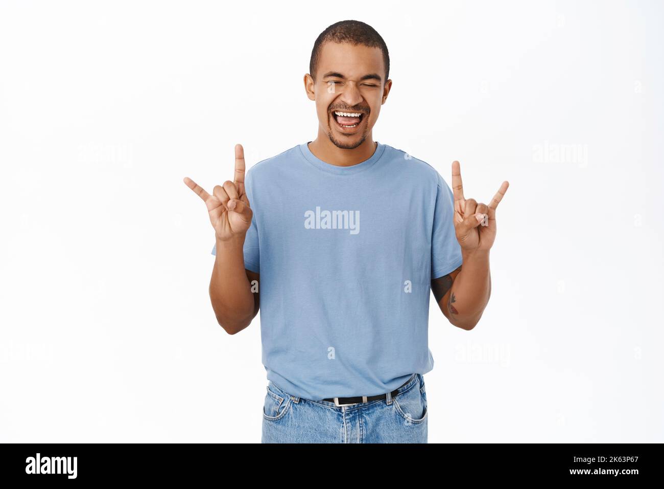 Enthusiastic guy shows rock on, heavy metal finger sign and looking ...