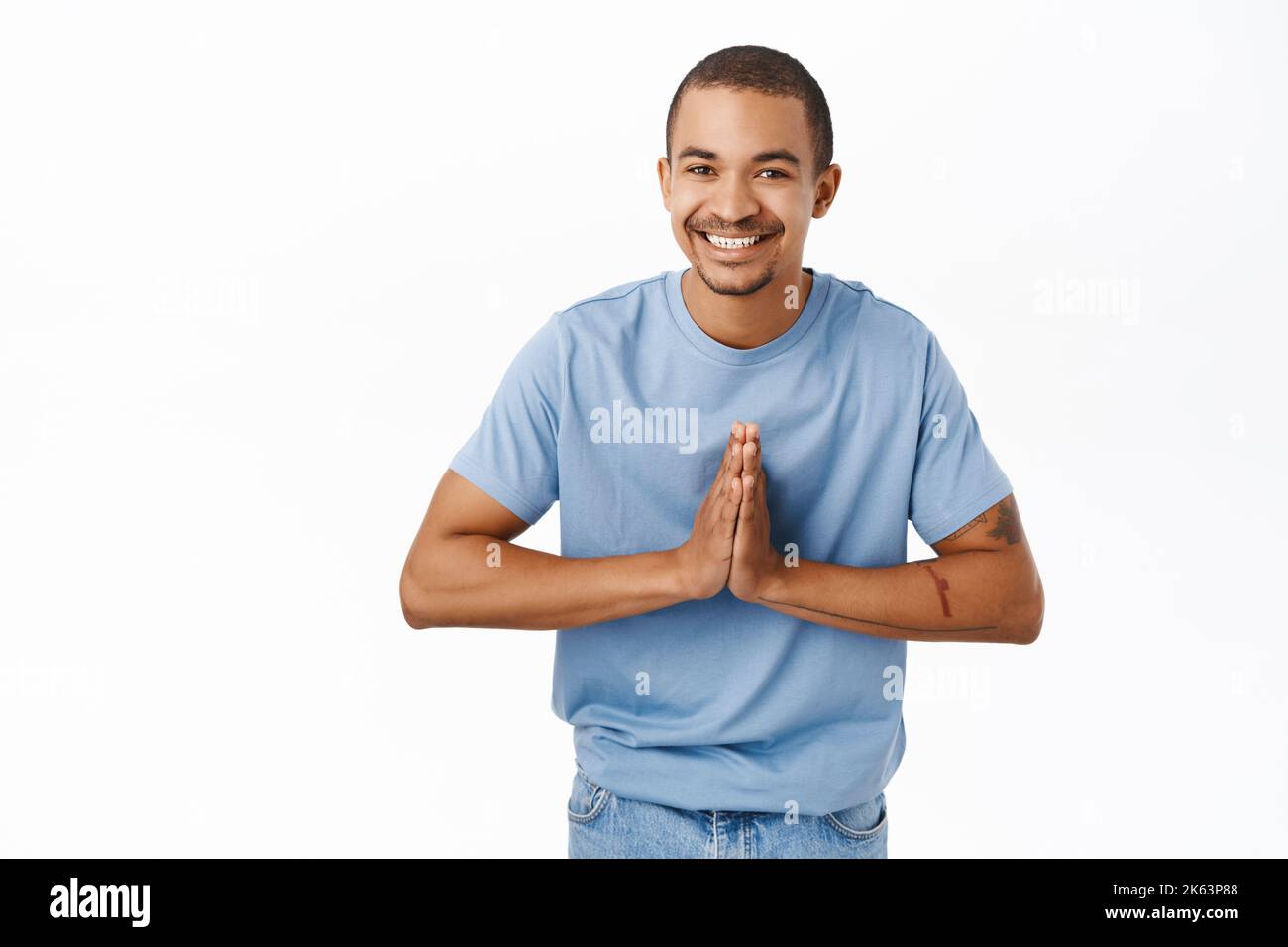 Namaste. Mindful young man meditating, holding hands in pray and ...
