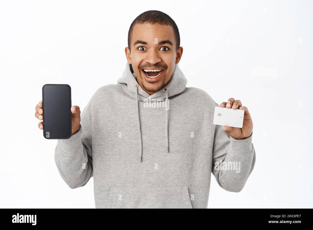Online banking, money transfer. Excited guy shows credit card and ...