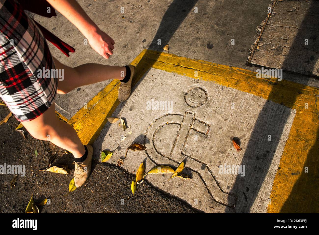 Handicap sign with a smiley face, street crossing, woman in a plaid ...