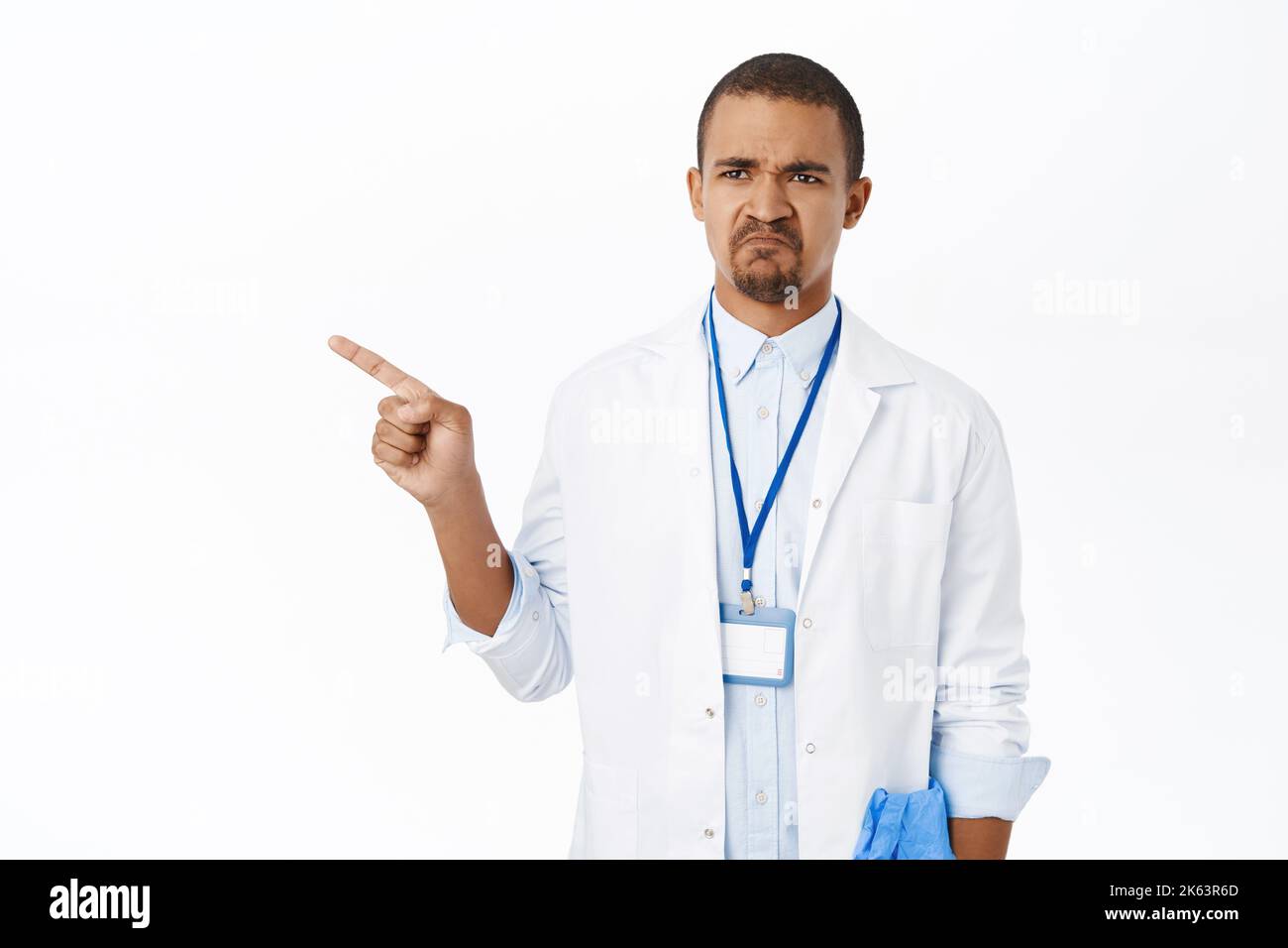 Sad male doctor, therapist pointing ad looking left with upset, unhappy ...