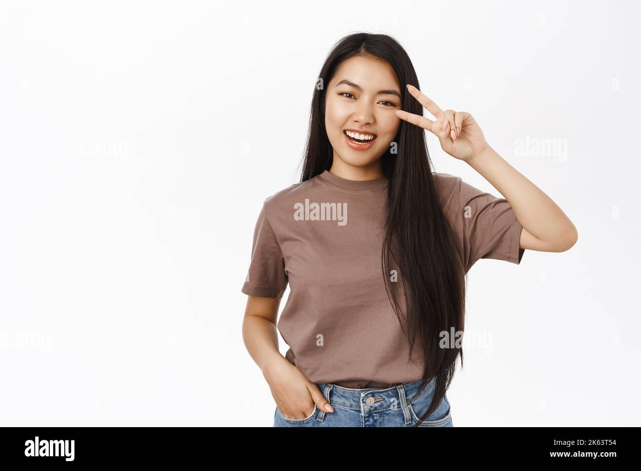 Portrait of smiling asian woman shows peace, v-sign and looks happy ...