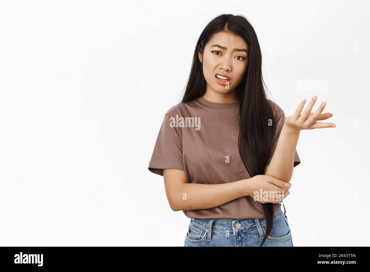 Confused korean girl looks puzzled, shrugs shoulders and looking ...
