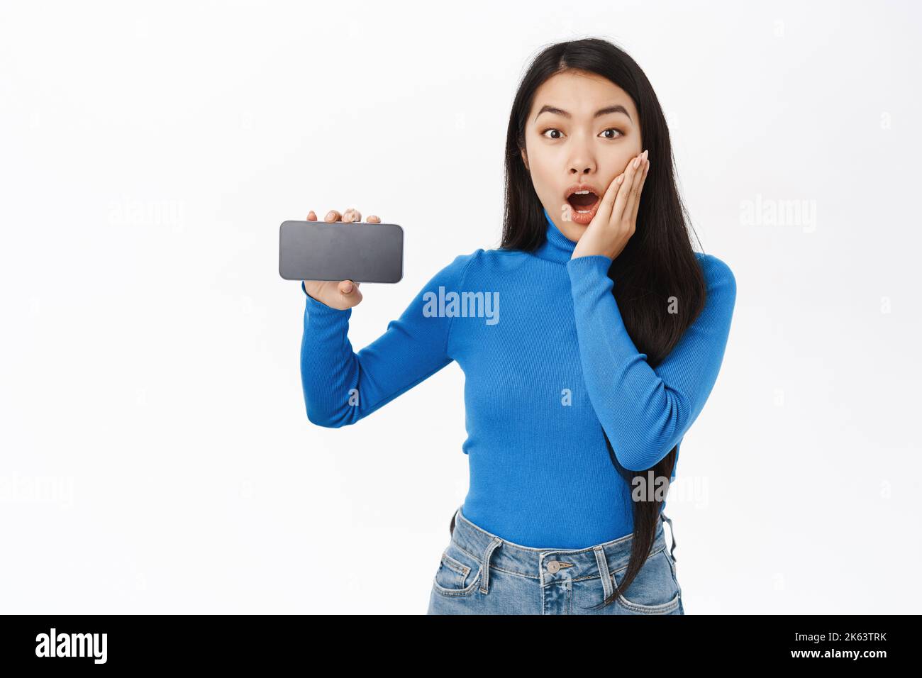 Technology. Smiling asian woman demonstrates smartphone app screen ...