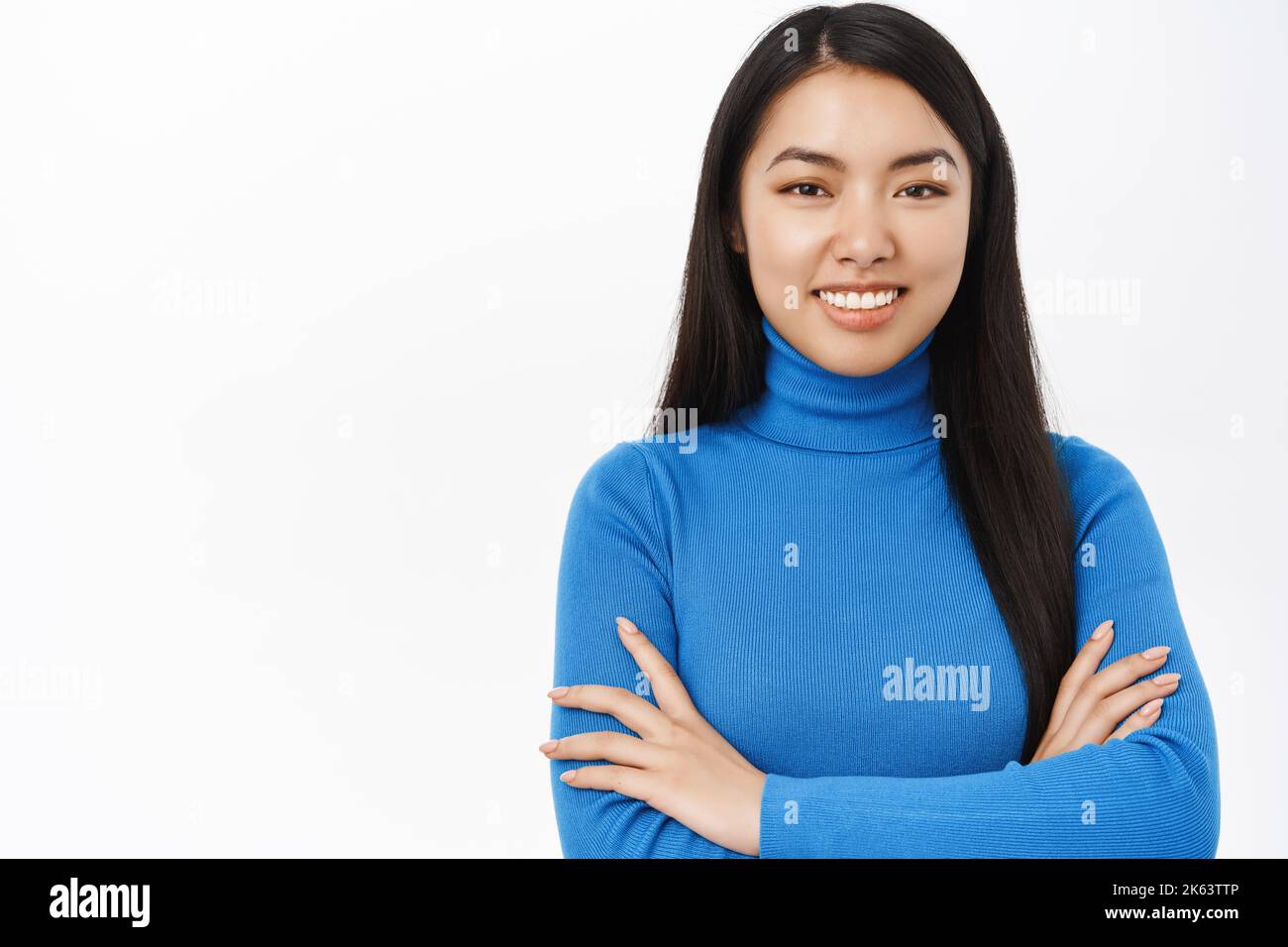Confidence. Smiling young asian woman in power pose, cross arms on ...