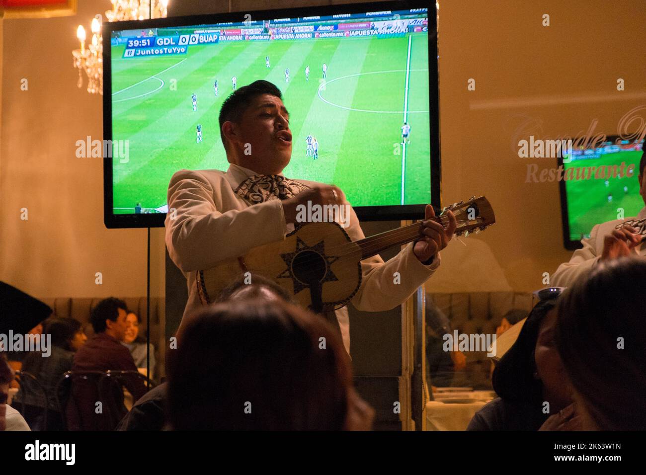 Mariachi singer singing at a bar in Guanajuato, Mexico, soccer game on ...