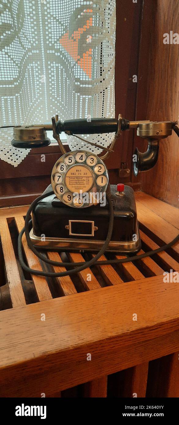 An antique vintage bakelite and copper telephone on wooden table by the ...