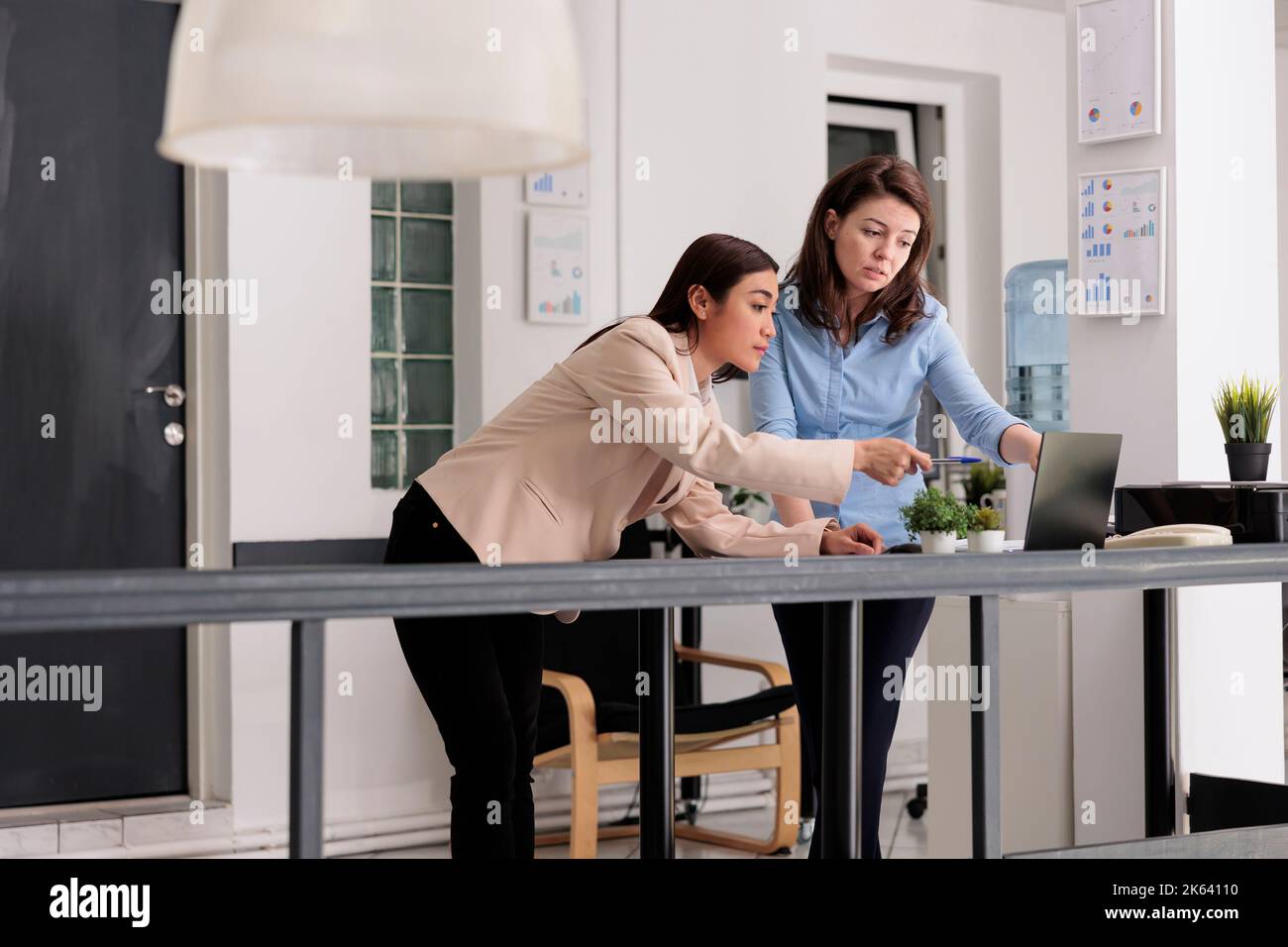 Employees collaboration, coworkers discussing company report in coworking space, woman pointing ...